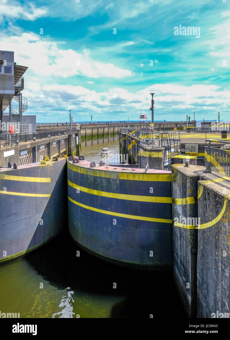 Lock opening at the Barage at Cardiff Bay. Shows small boat entering ...