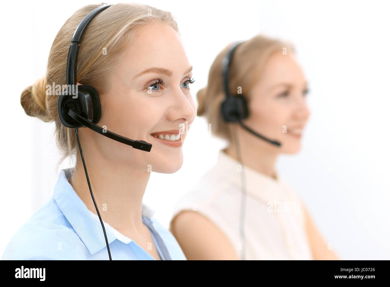 Call center. Focus on beautiful blonde woman in headset Stock Photo - Alamy