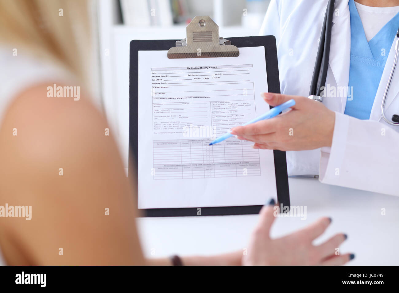 Close up of a doctor and patient hands while phisician pointing into ...