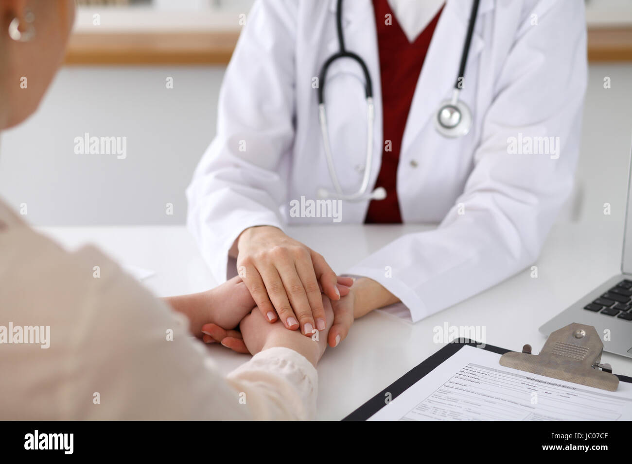 Hand of doctor reassuring her female patient Stock Photo - Alamy