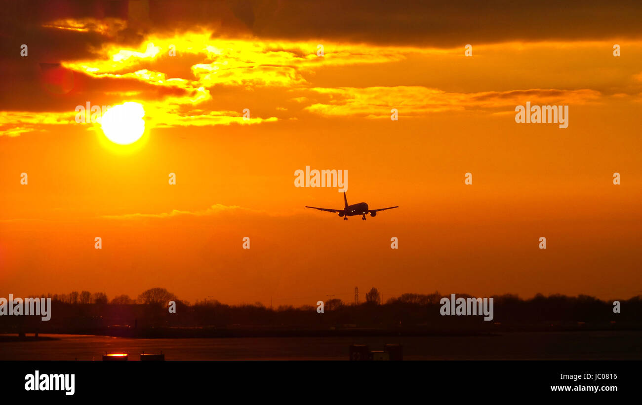 Silhouette of aircraft landing at sunset, Heathrow Airport London Stock ...