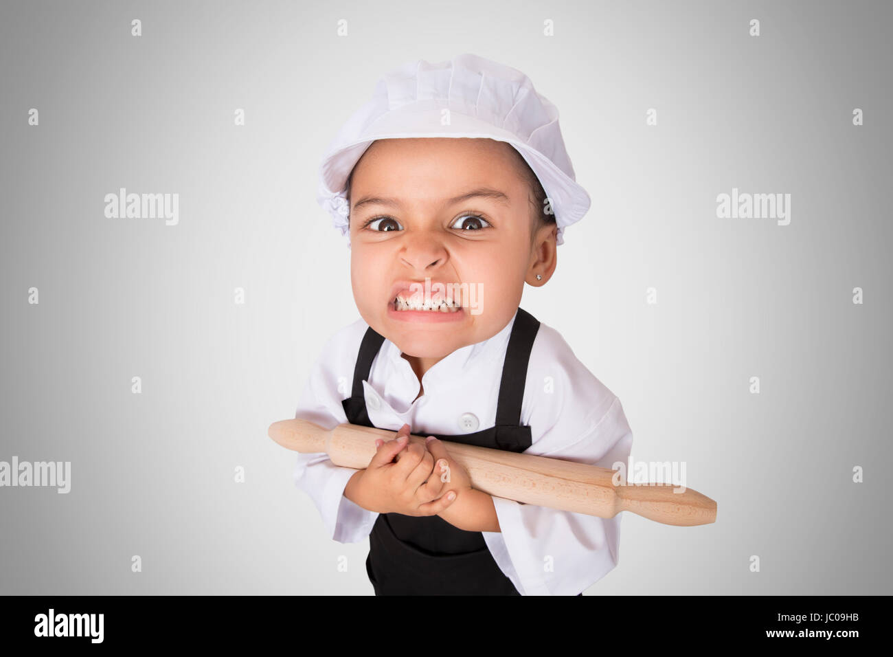 Portrait of a funny and angry four years girl on grey background wit a ...