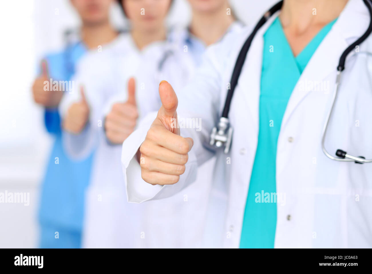 Group of doctors showing OK or approval sign with thumb up. High level ...