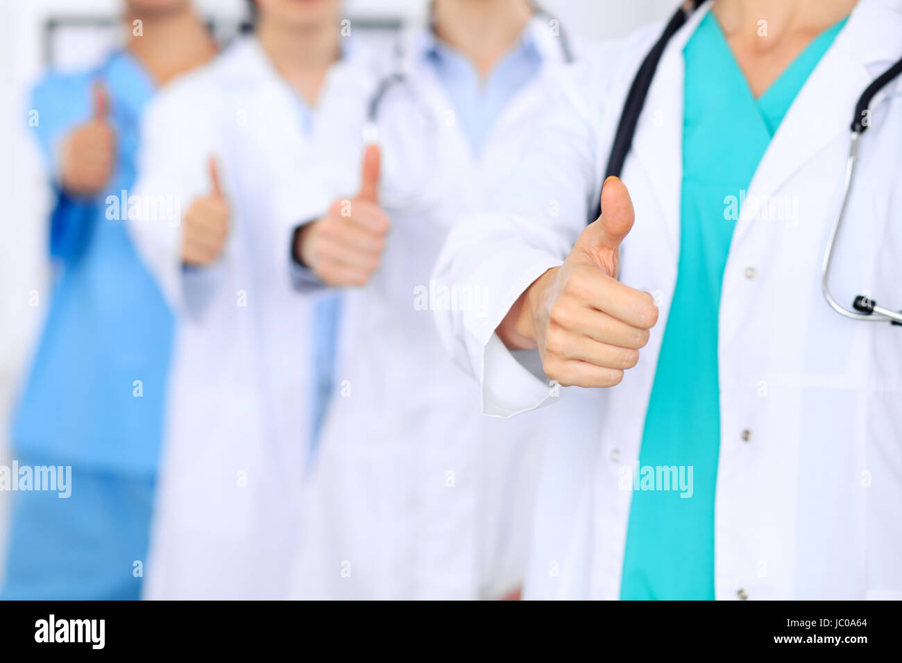 Group of doctors showing OK or approval sign with thumb up. High level ...