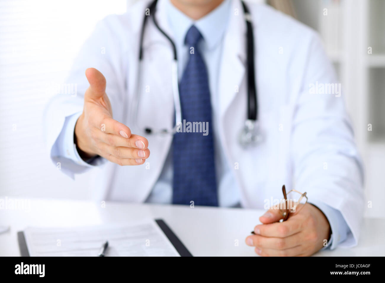 Male medicine doctor offering helping hand for handshake. Partnership ...
