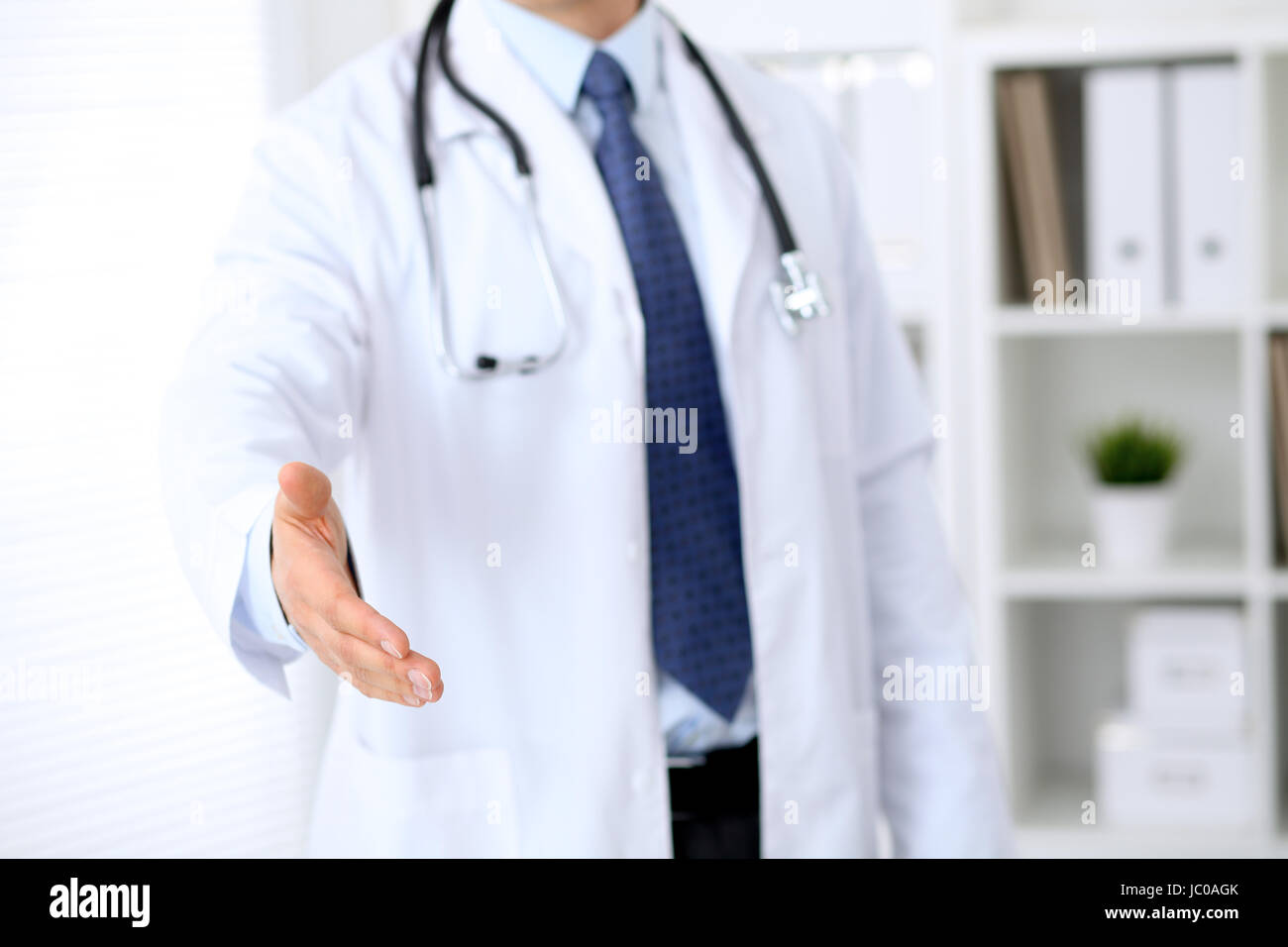 Male medicine doctor offering helping hand for handshake. Partnership ...