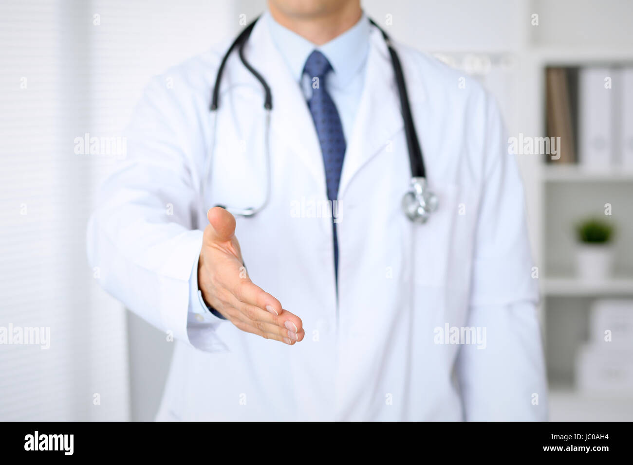 Male medicine doctor offering helping hand for handshake. Partnership ...