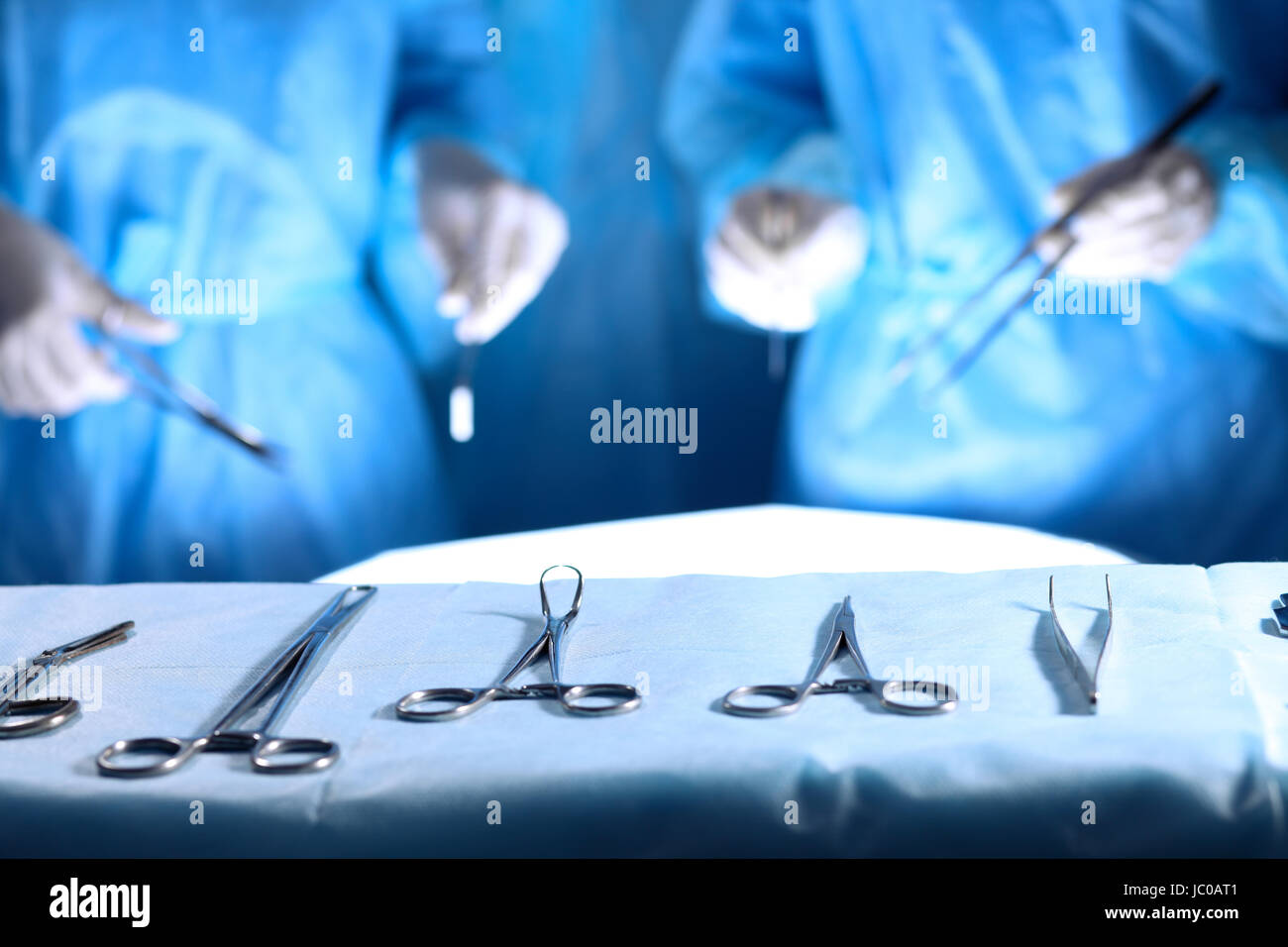 Surgical tools lying on the table while group of surgeons at background ...