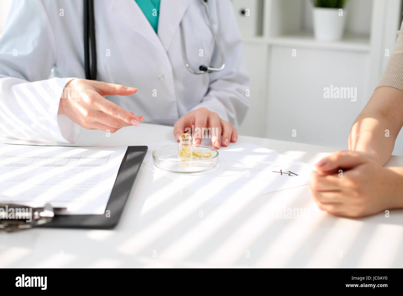 Doctor and patient are discussing something, just hands at the table ...