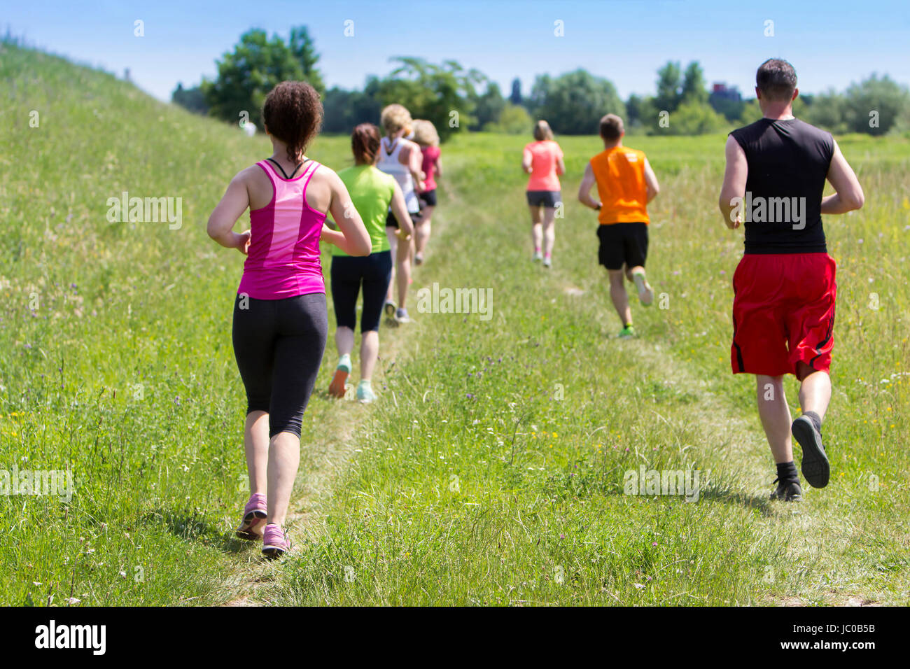 Outdoor cross-country running, group of young active people running in ...