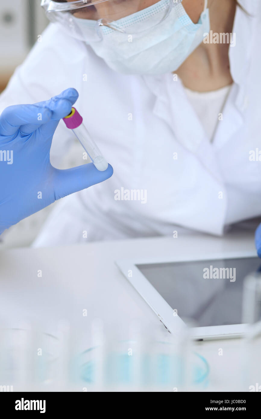 Close up of scientific research hands with clear solution in laboratory ...