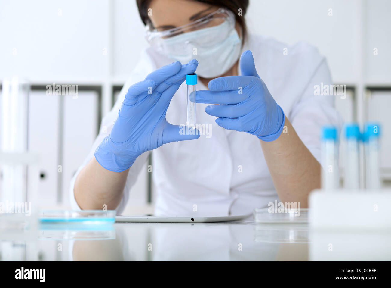 Close up of scientific research hands with clear solution in laboratory ...