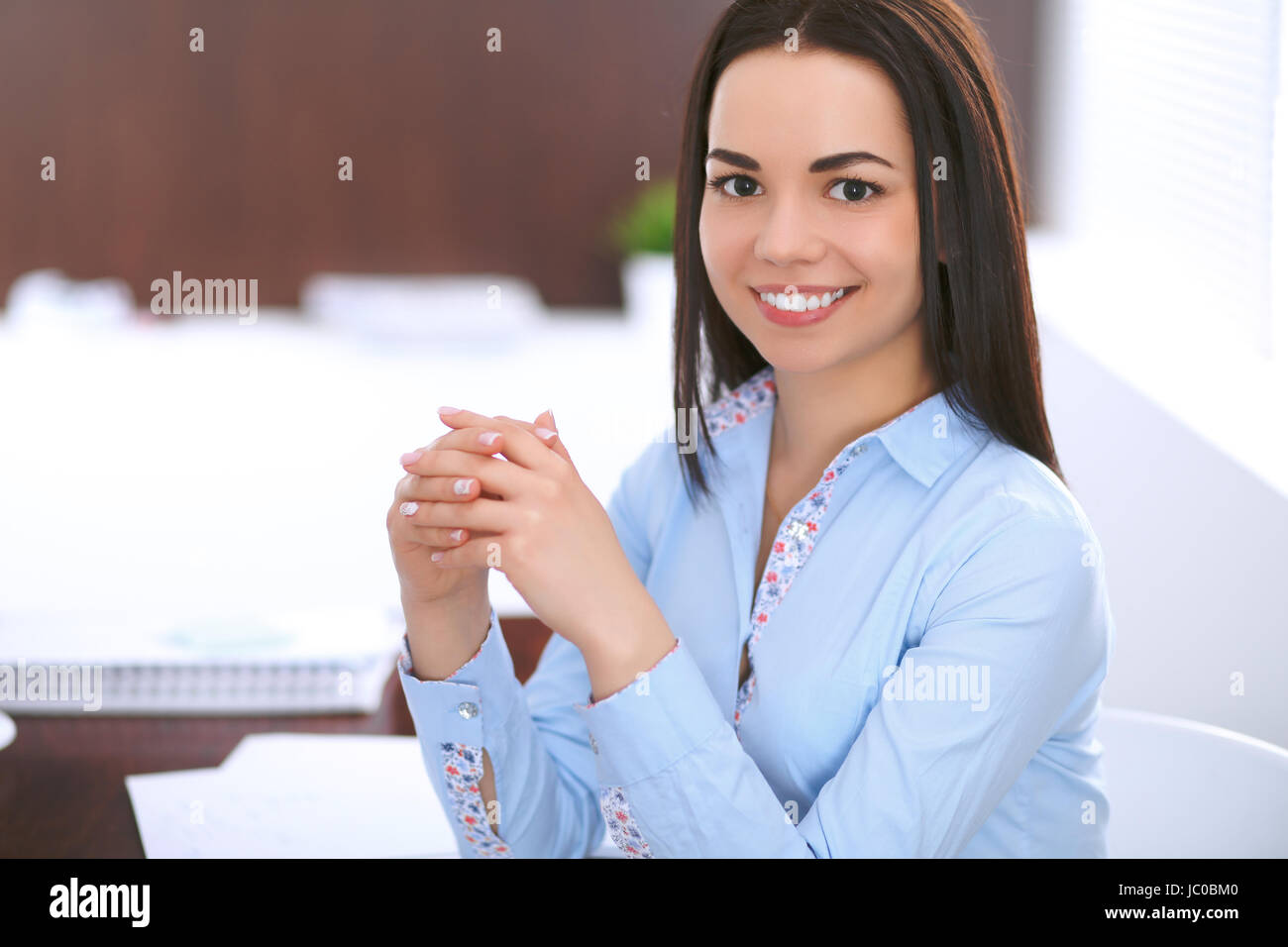 Young business woman sitting a at the table in office Stock Photo - Alamy
