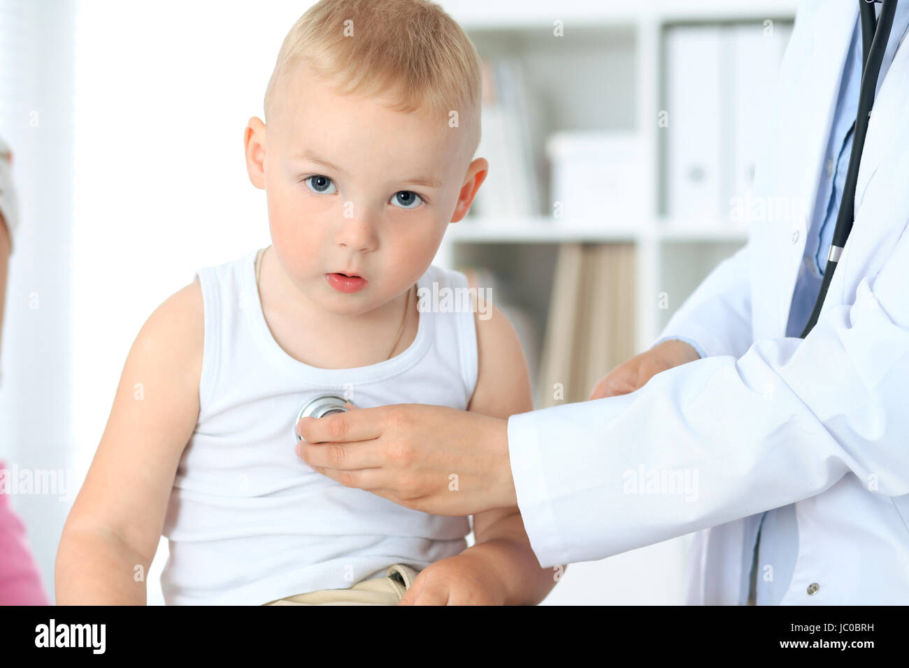 Doctor examining a child patient by stethoscope Stock Photo - Alamy