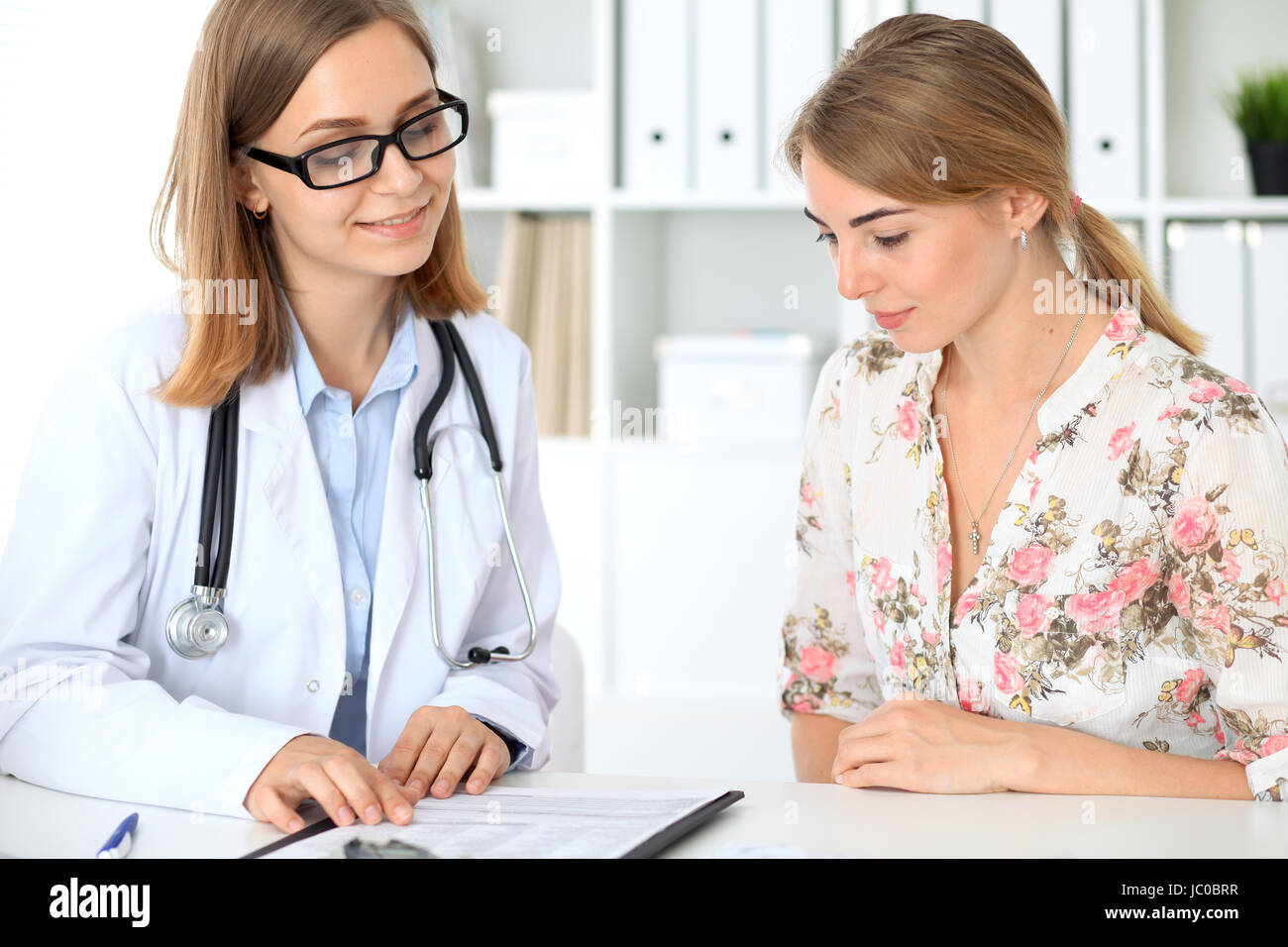 Doctor and patient sitting at the desk Stock Photo - Alamy