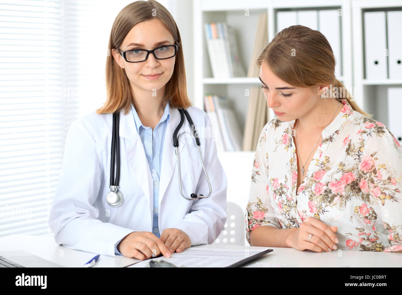Doctor and patient sitting at the desk Stock Photo - Alamy