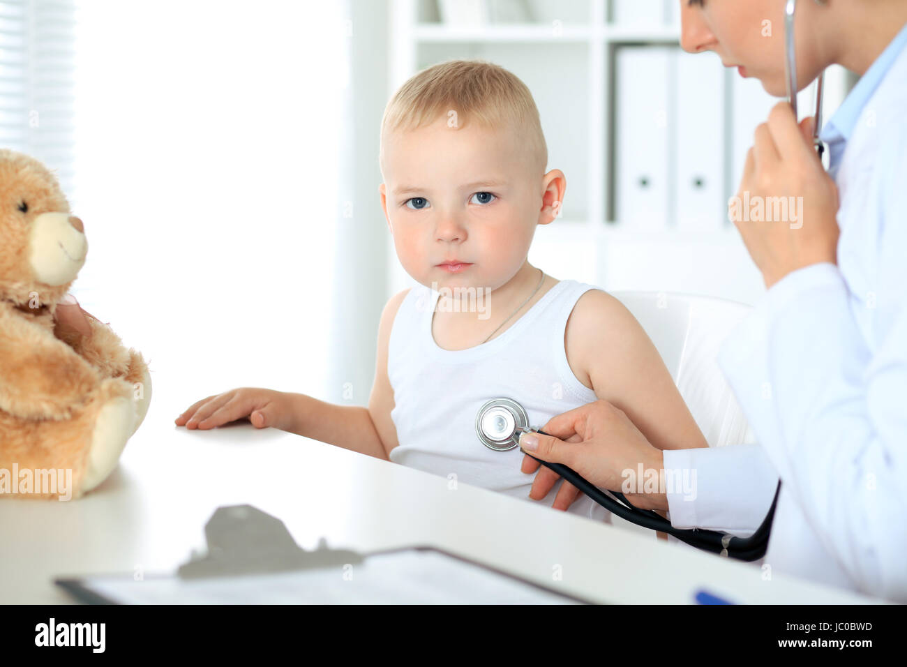 Doctor examining a child patient by stethoscope Stock Photo - Alamy