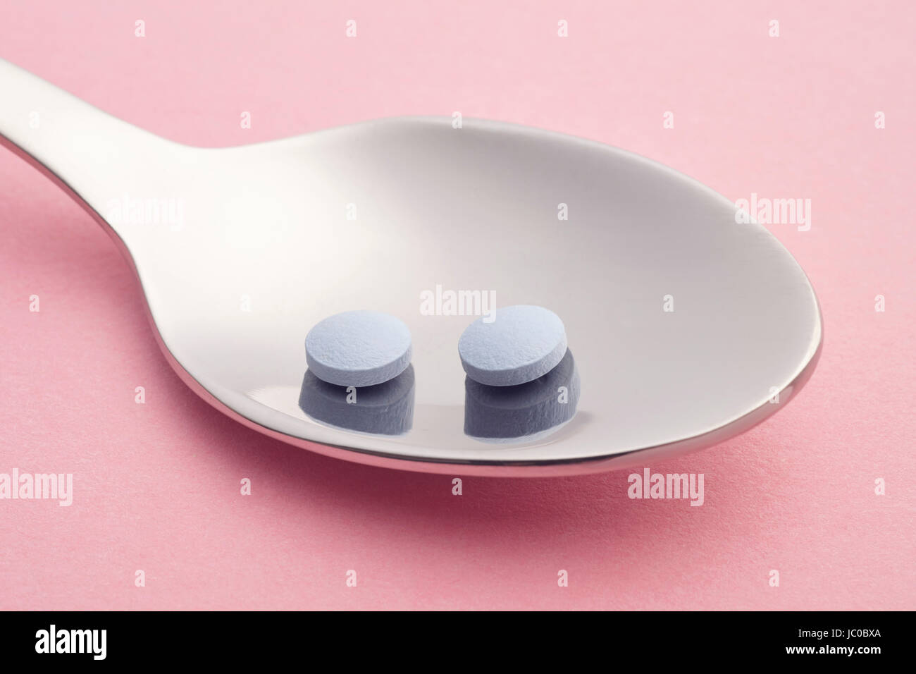 Pills and spoon detail. Pink background. Medicament treatment. Health ...