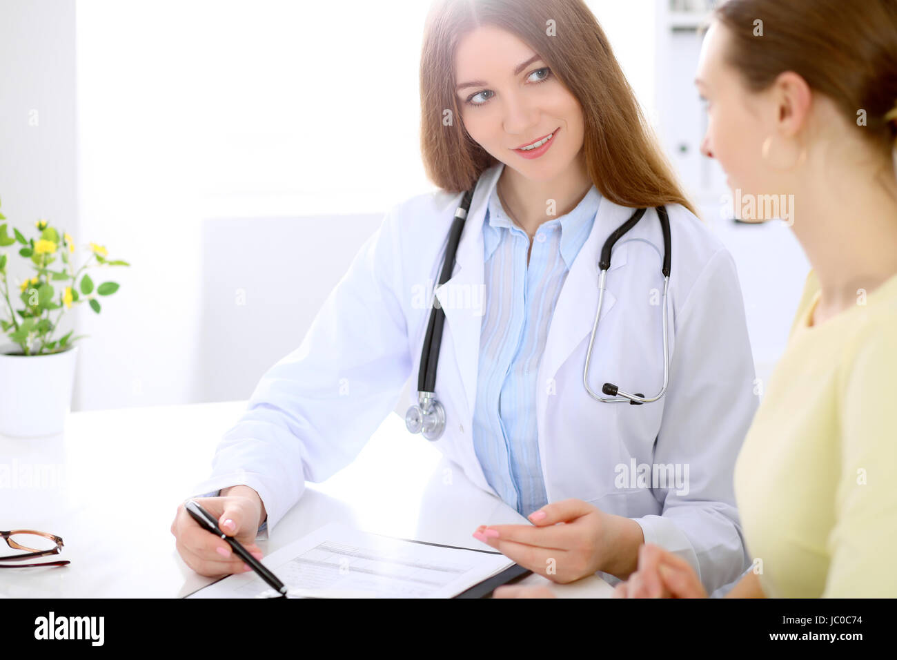 Doctor and patient sitting at the desk near window Stock Photo - Alamy