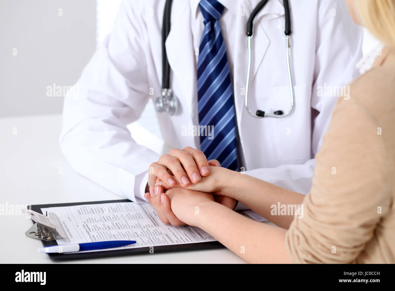 Hand of doctor reassuring her female patient. Medical ethics and trust ...