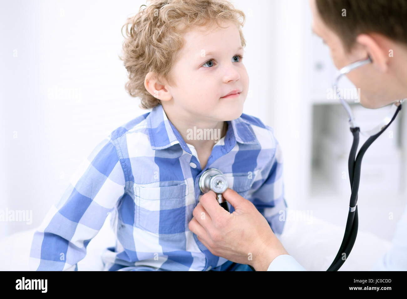 Doctor examining a child patient by stethoscope Stock Photo - Alamy
