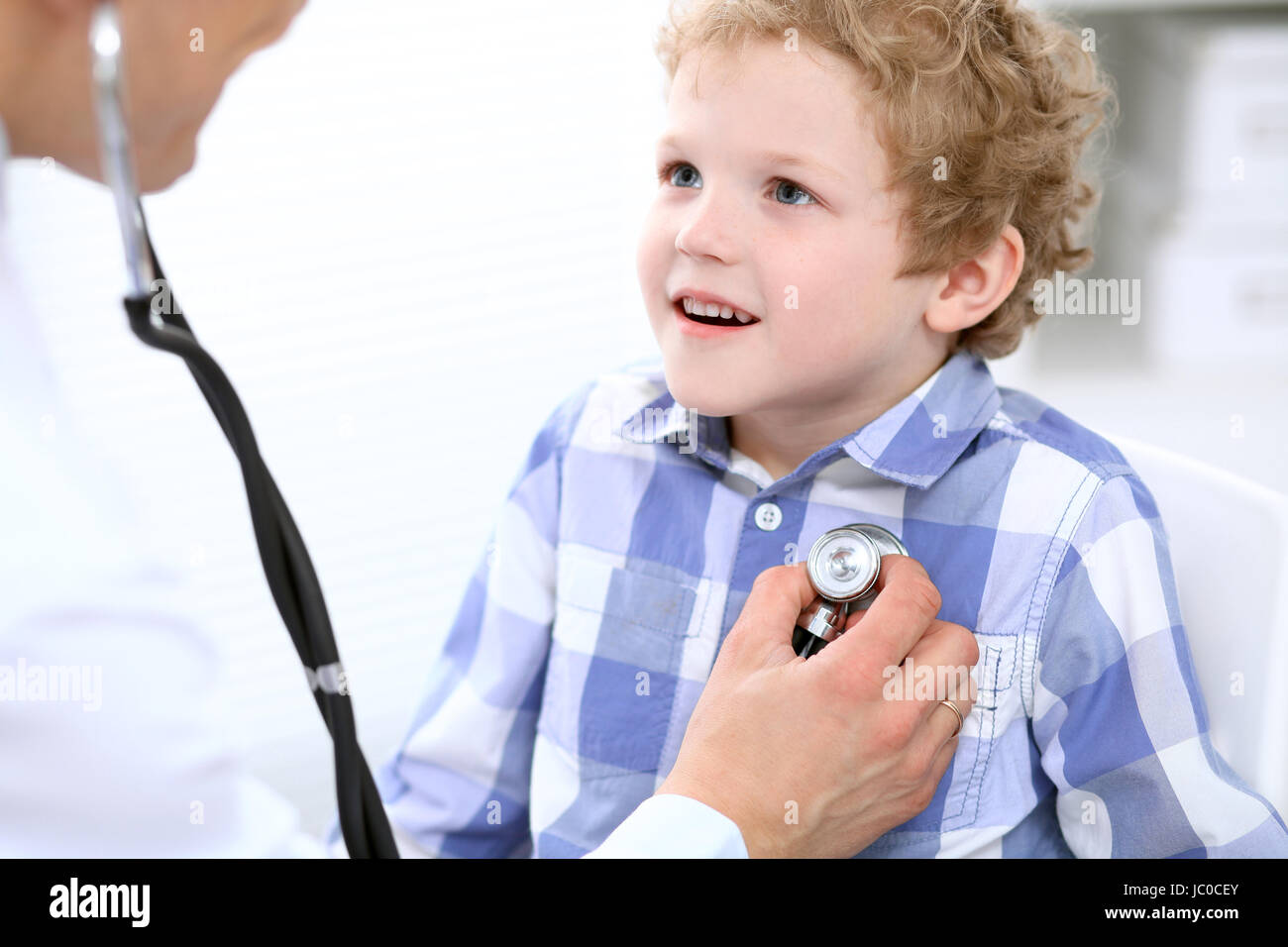 Doctor examining a child patient by stethoscope Stock Photo - Alamy