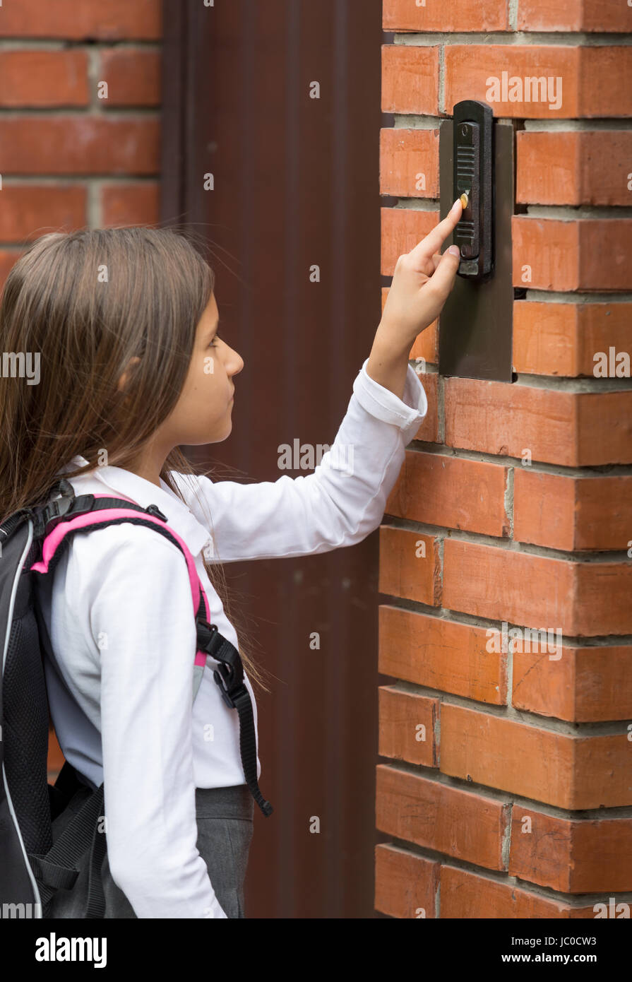 Closeup photo of cute schoolgirl ringing in doorbell Stock Photo - Alamy
