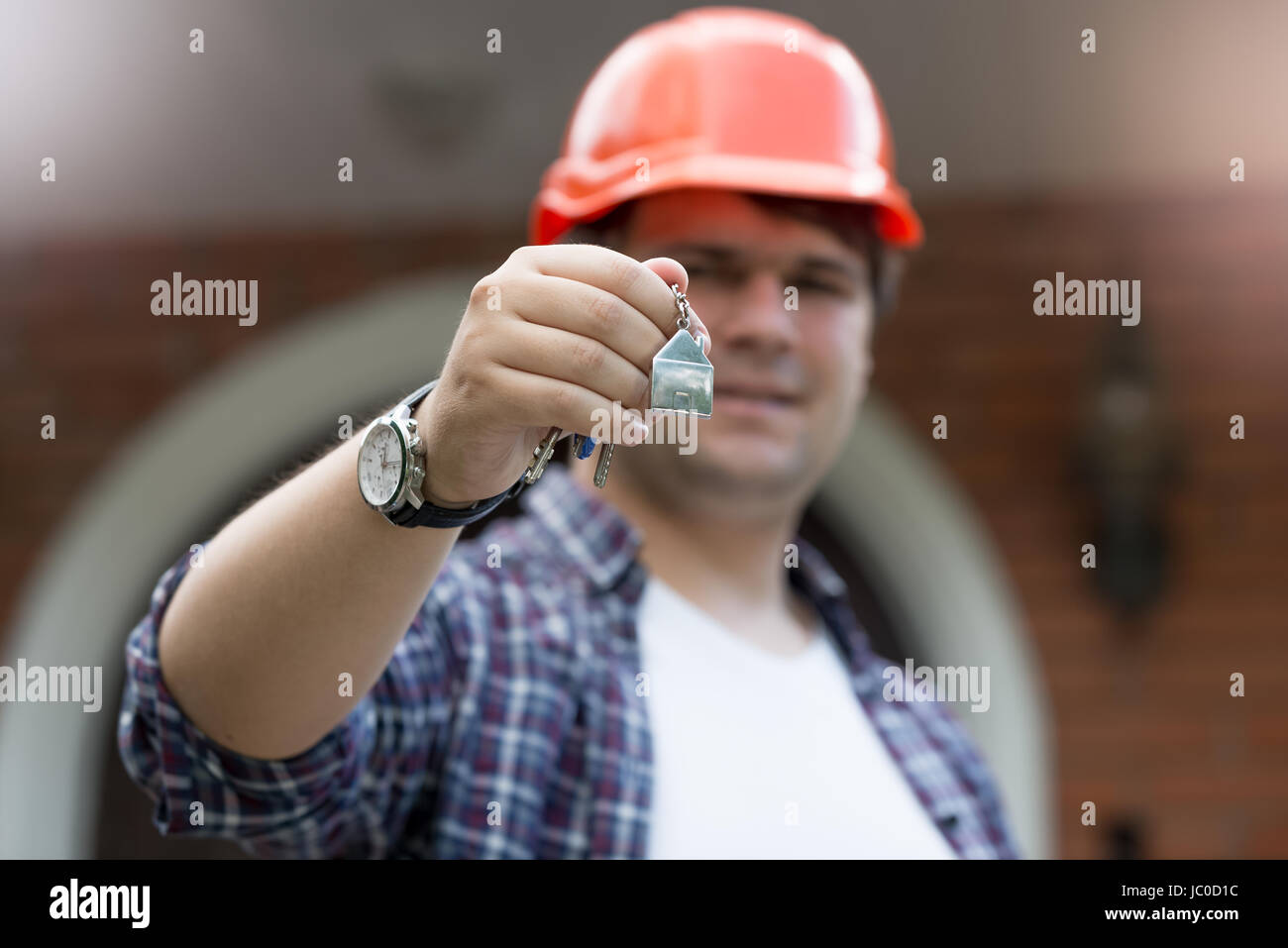 Closeup photo of construction worker holding keys from new house in ...
