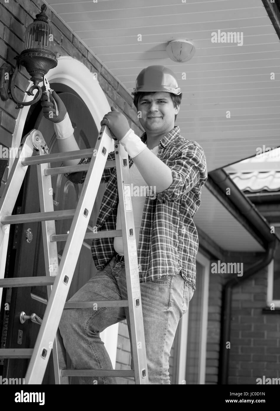 Black and white portrait of smiling electrician posing on top of ...