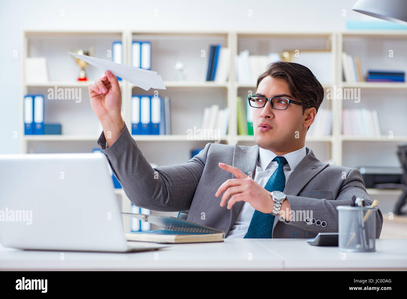 Businessman with paper airplane in office Stock Photo - Alamy