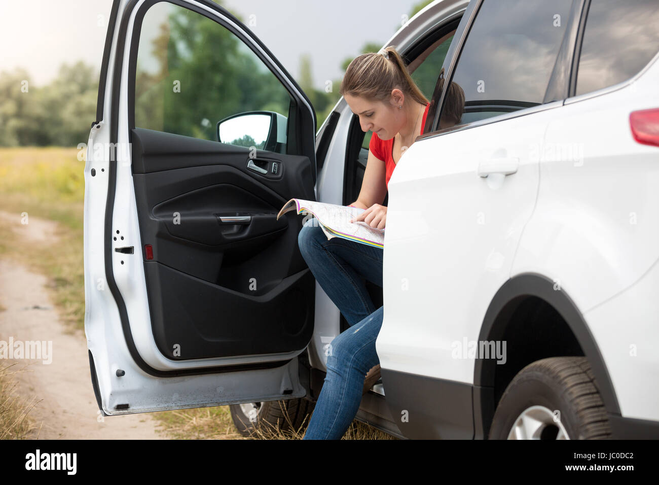 Young female driver got lost and looking for the route in map Stock ...