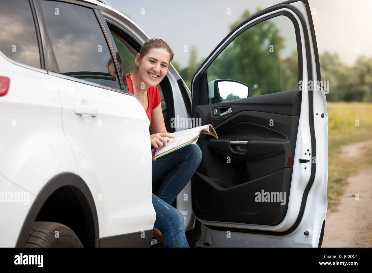 Portrait of beautiful young woman got lost while driving car at ...
