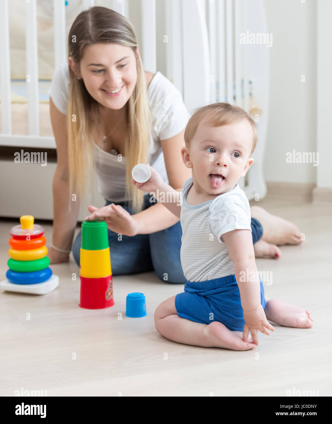 Beautiful smiling mother assembling toy pyramid with her baby boy Stock ...