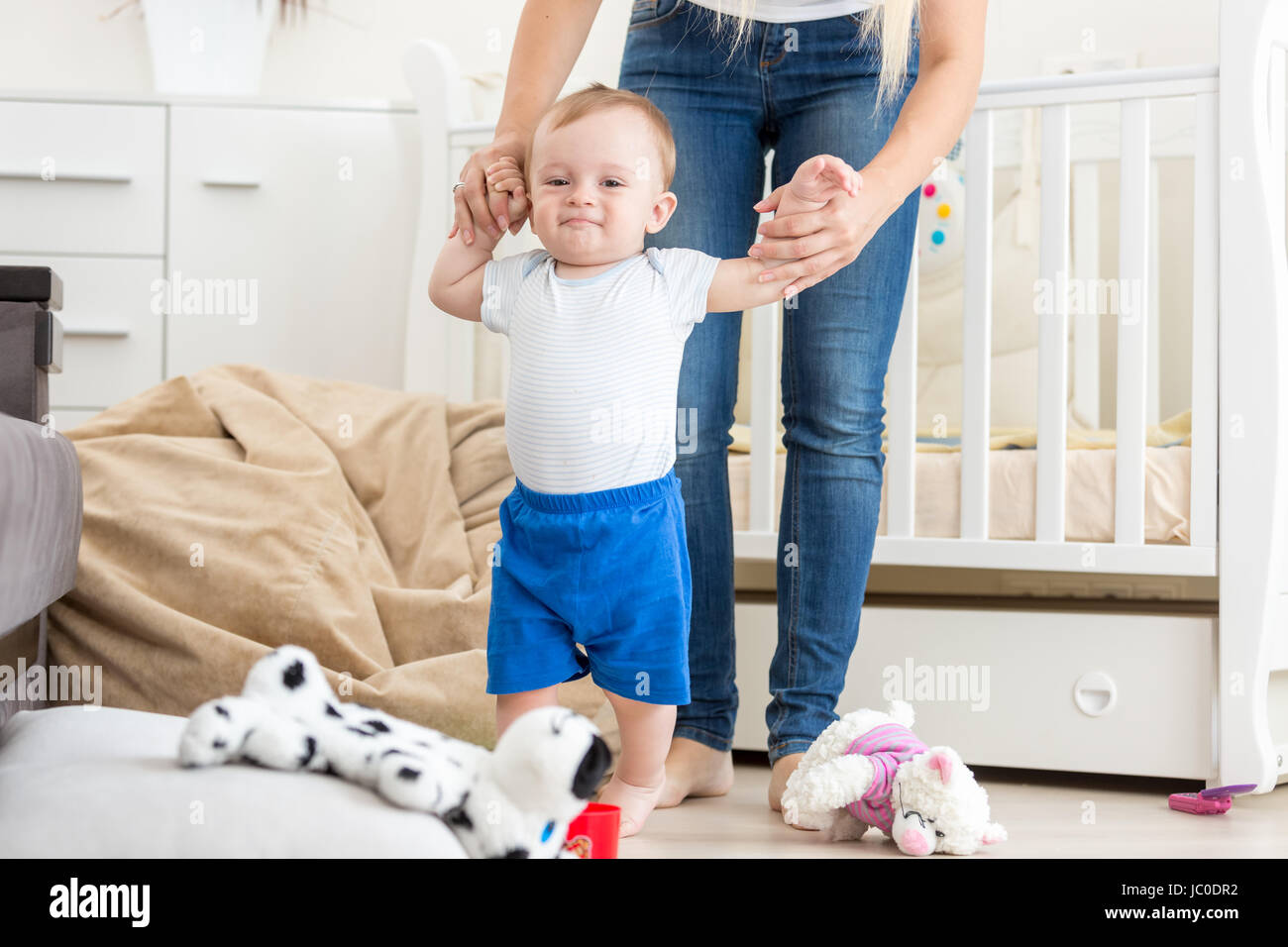 Cute adorable baby learning how to walk with mother at home Stock Photo ...