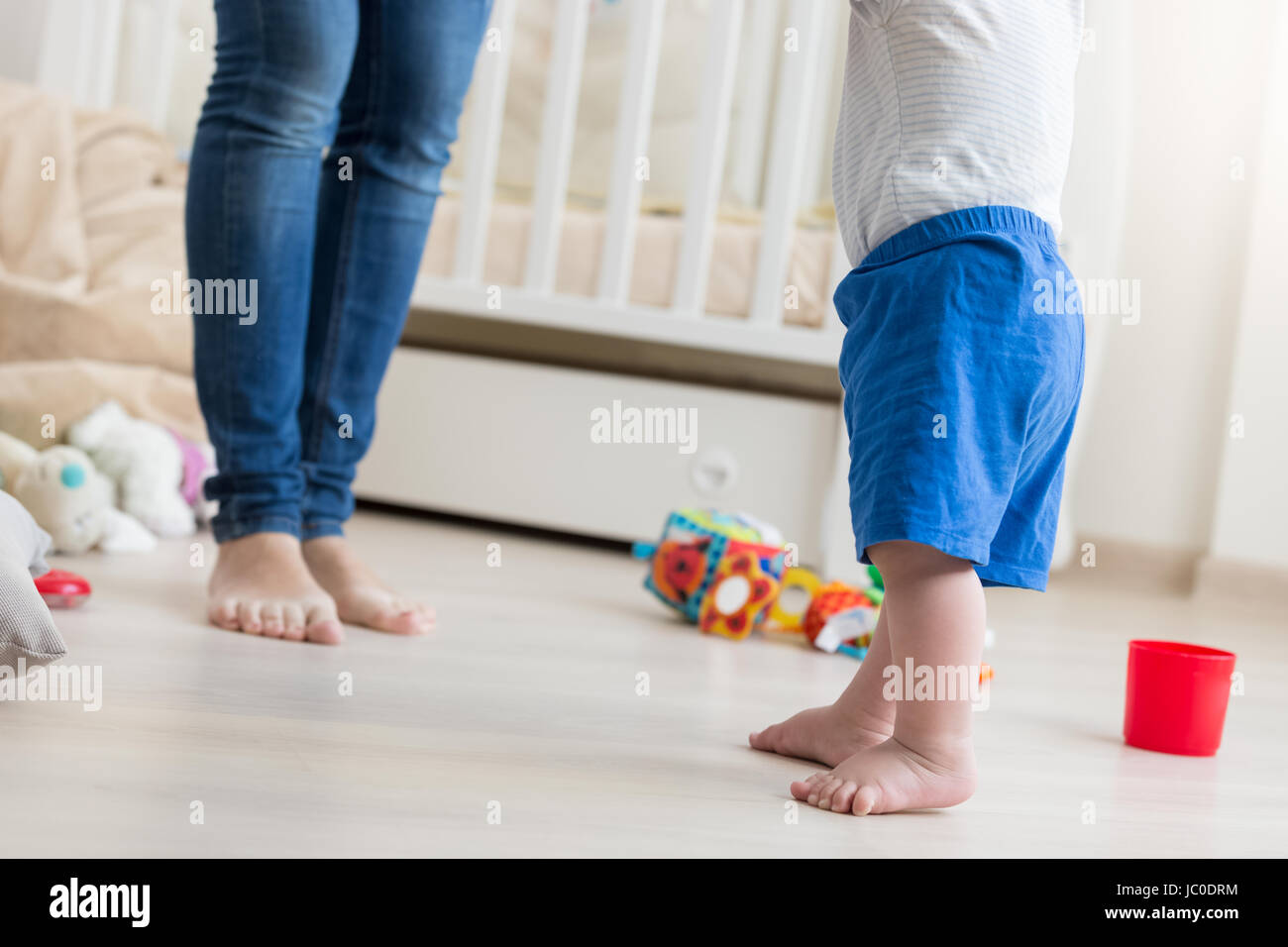 Closeup image of 10 months old baby boy making first steps at living ...