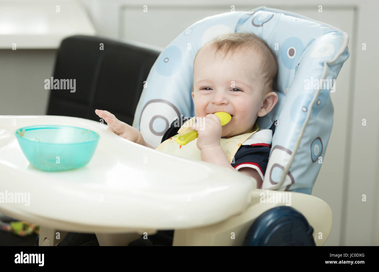 Portrait of cute smiling baby boy eating with spoon Stock Photo - Alamy