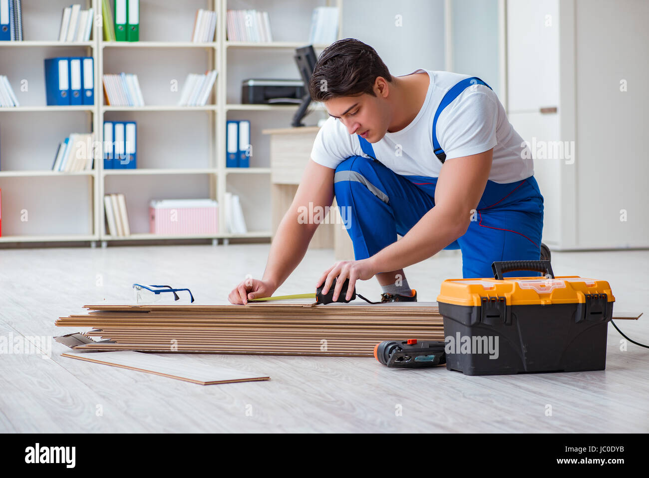 Young worker working on floor laminate tiles Stock Photo - Alamy