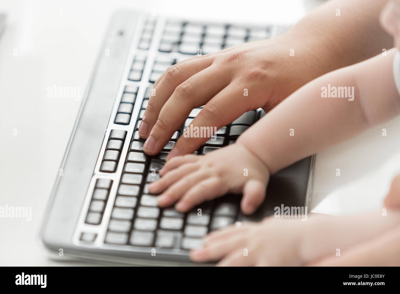 Closeup photo of father teaching his baby how to use computer keyboard ...
