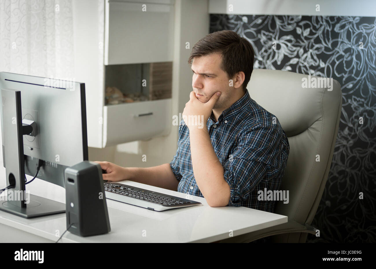 Portrait of concentrated young man working at computer Stock Photo - Alamy