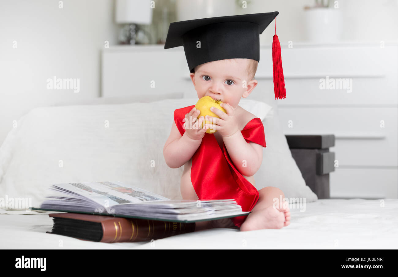 Portrait of adorable baby boy in graduation cap sitting in from of ...