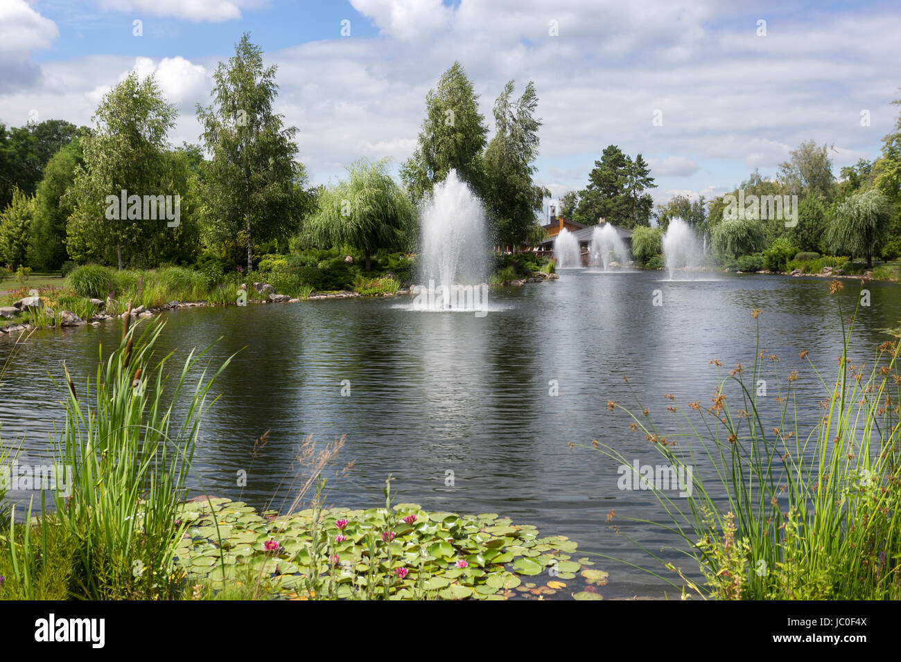 Beautiful pond with fountains at formal garden Stock Photo - Alamy