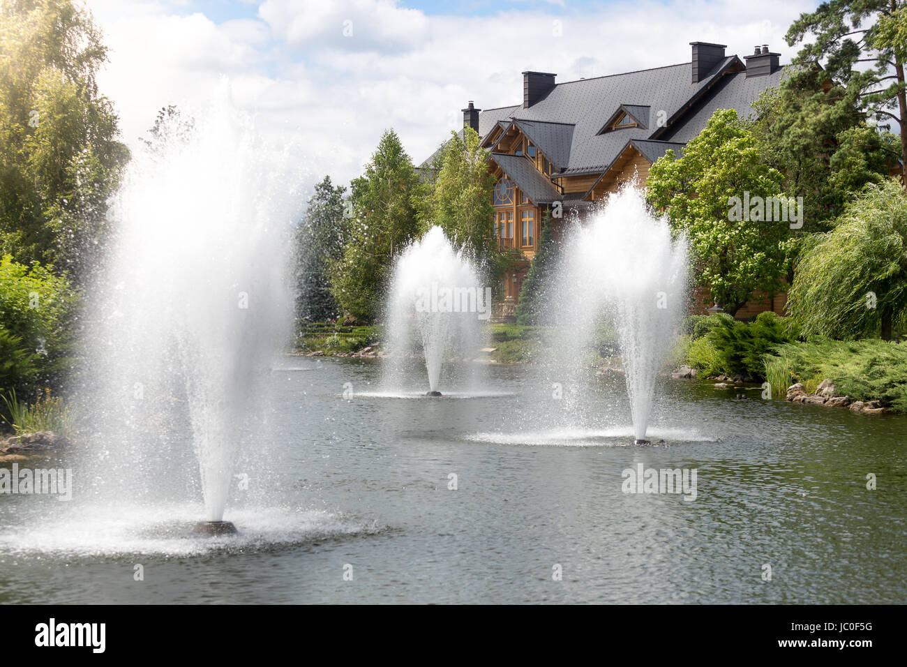 Beautiful view on three high fountains in pond at luxury mansion Stock ...