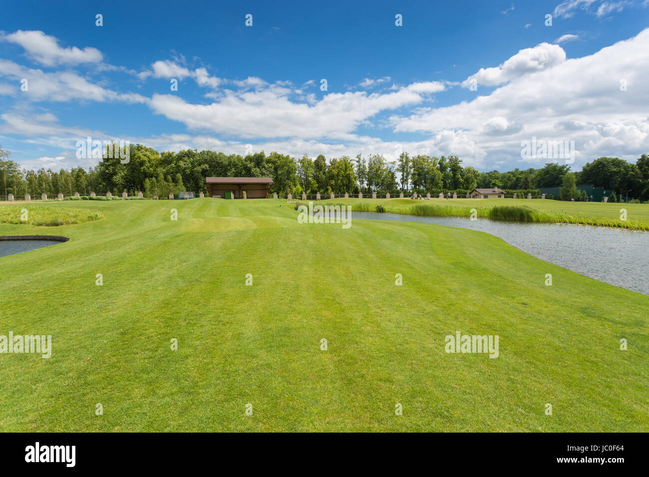 Beautiful golf course with perfect green grass and water hindrance at ...