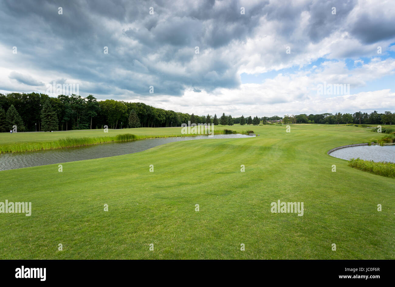 View on golf course at cold day with rainy clouds on sky Stock Photo ...
