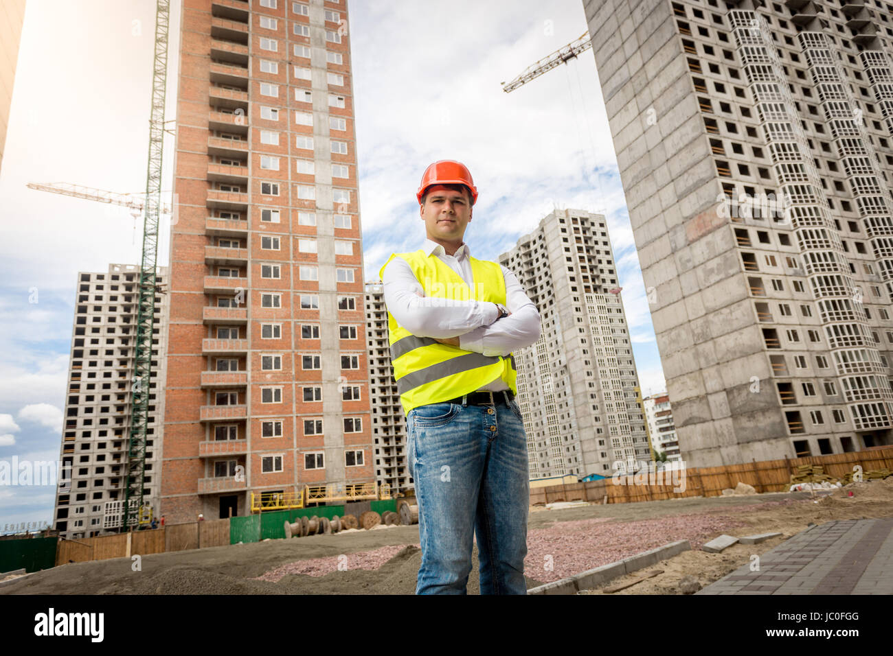 Portrait of smiling confident architect standing at buildings under ...