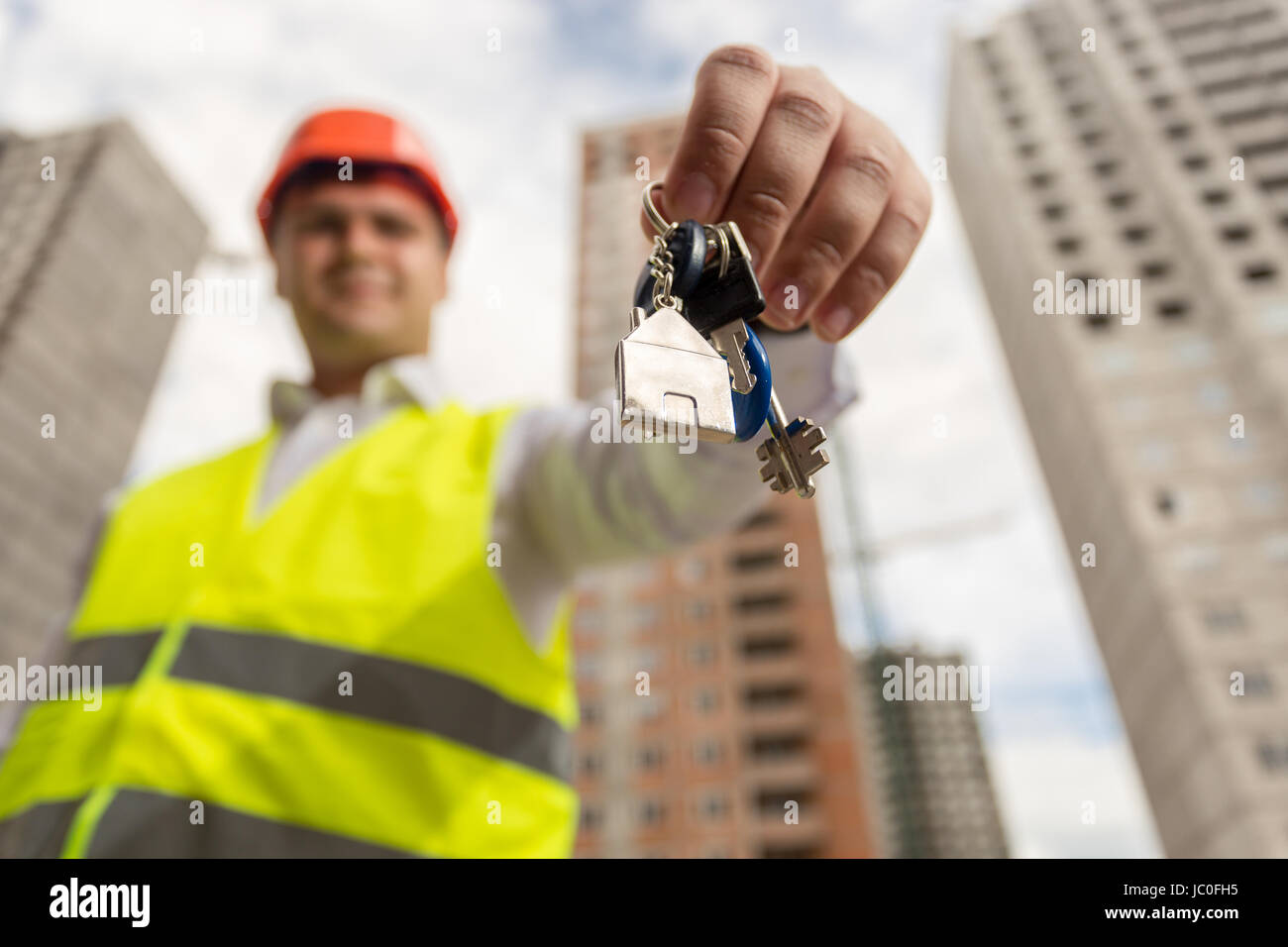 Closeup portrait of smiling construction engineer showing keys from new ...