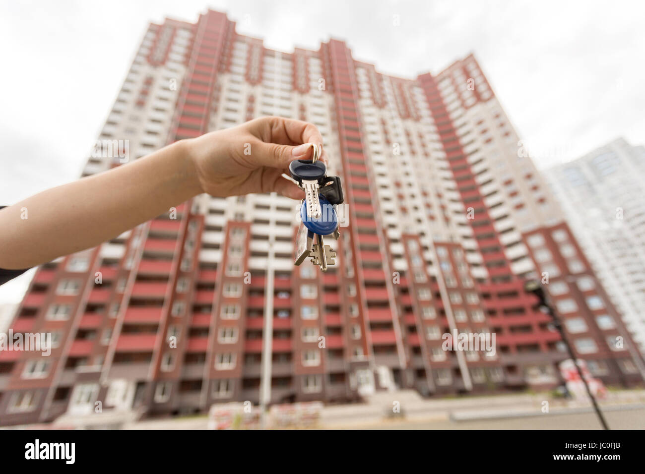 Closeup image of female hand holding keys from new apartment. New big ...