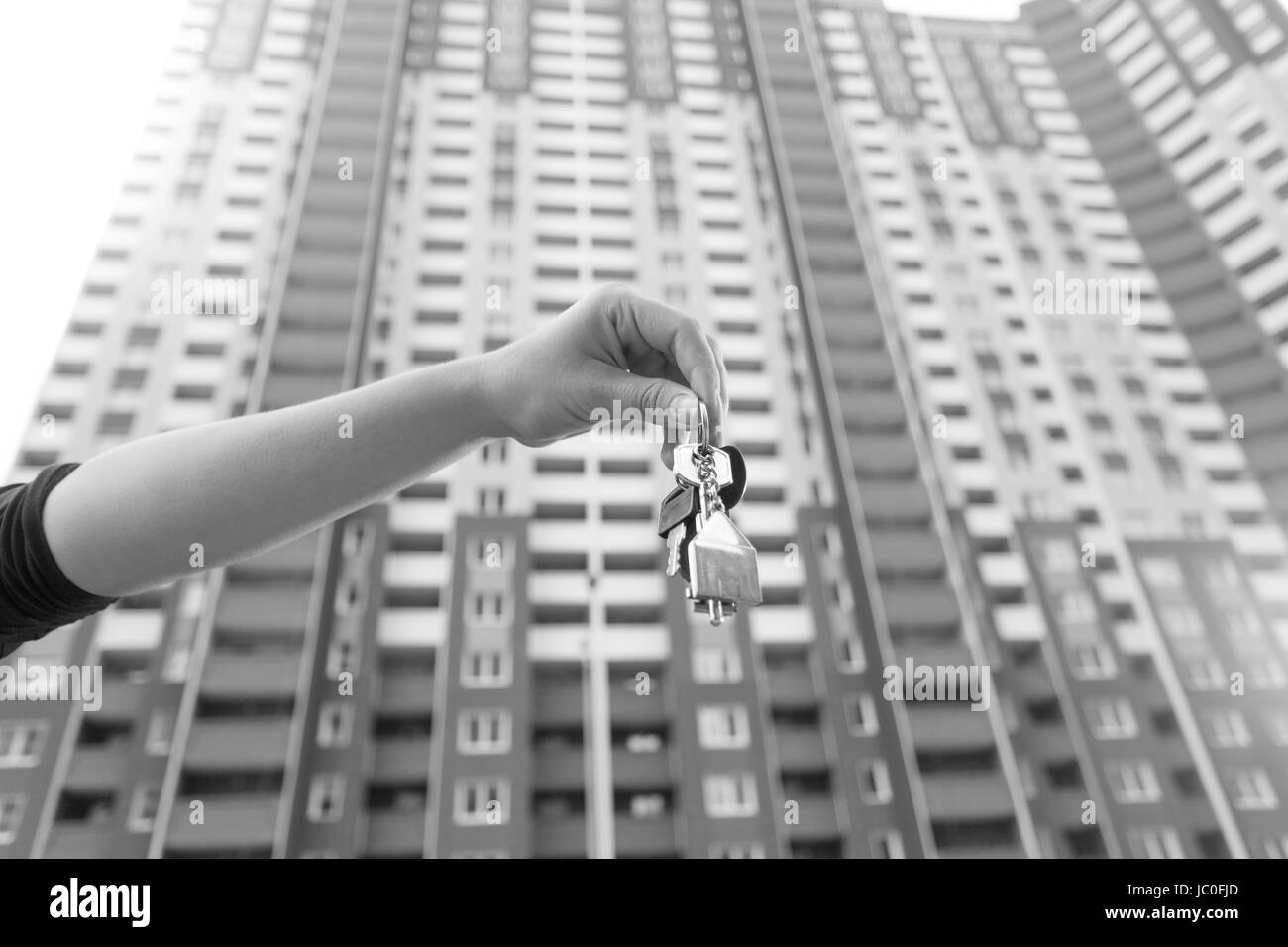 Black and white conceptual image of hand holding keys from new home ...