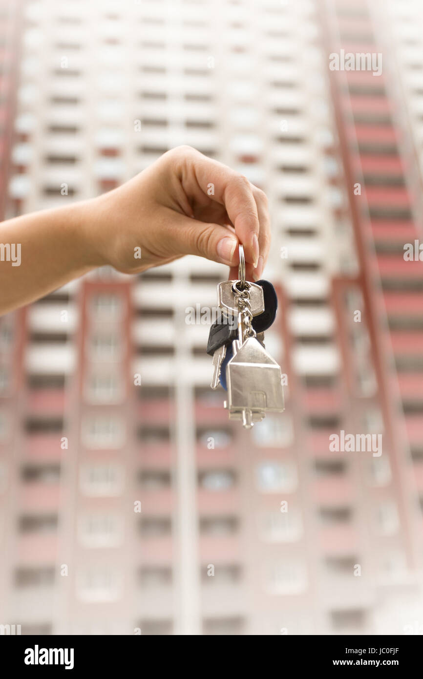 Closeup image of hand holding keys against high new building Stock ...