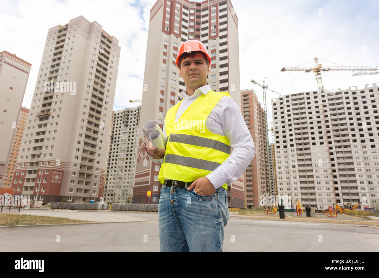 Portrait of construction inspector standing on building site and ...